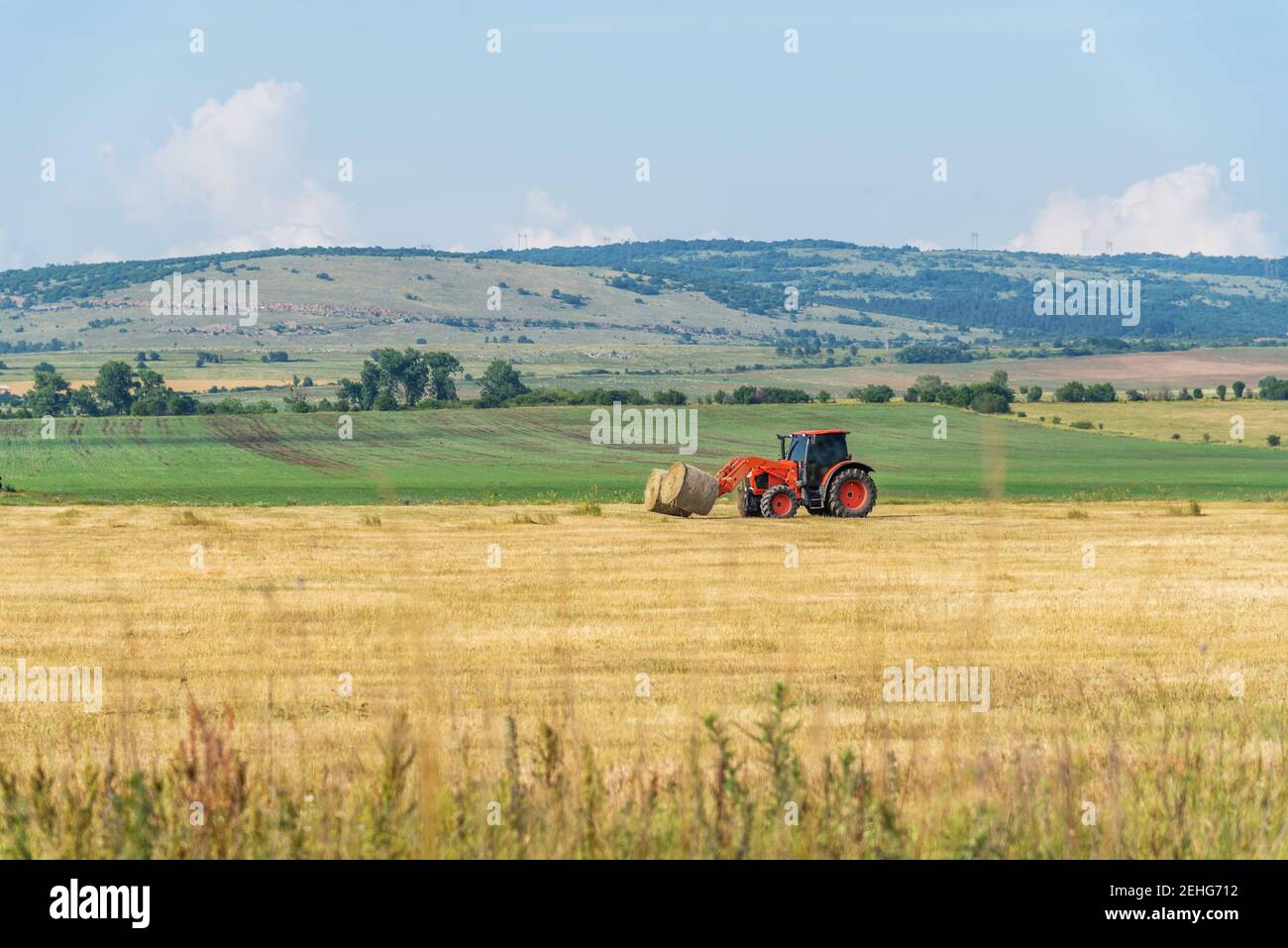 Tractor working with Hay Bale Stock Photo - Alamy