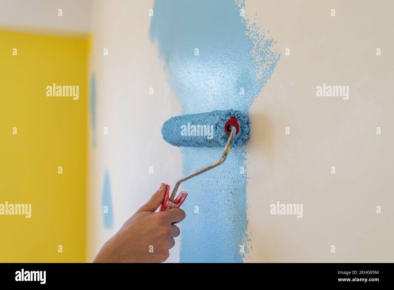 Decorator's hand painting wall with roller Stock Photo - Alamy
