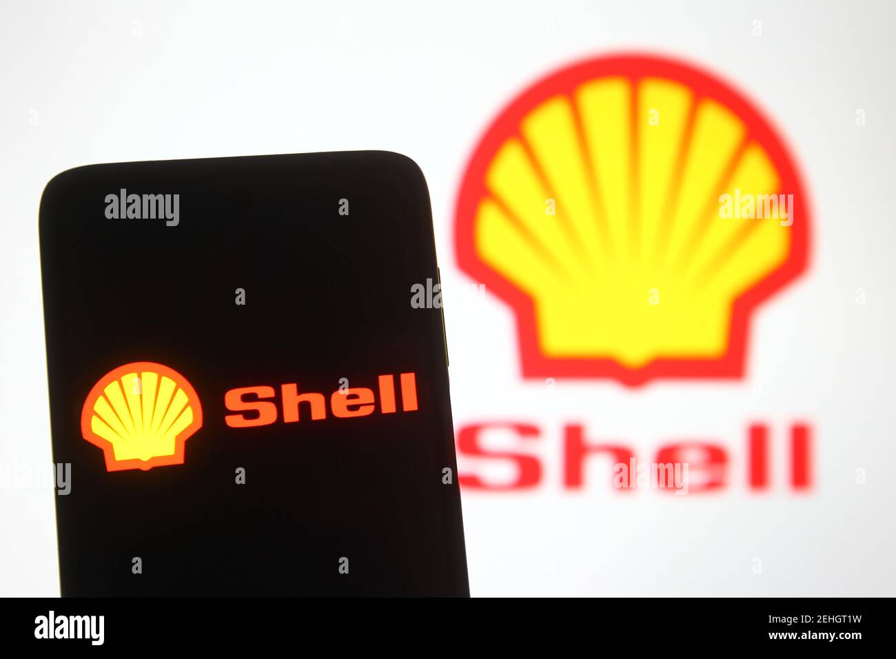 In this photo illustration a Shell logo is seen on a smartphone and a ...