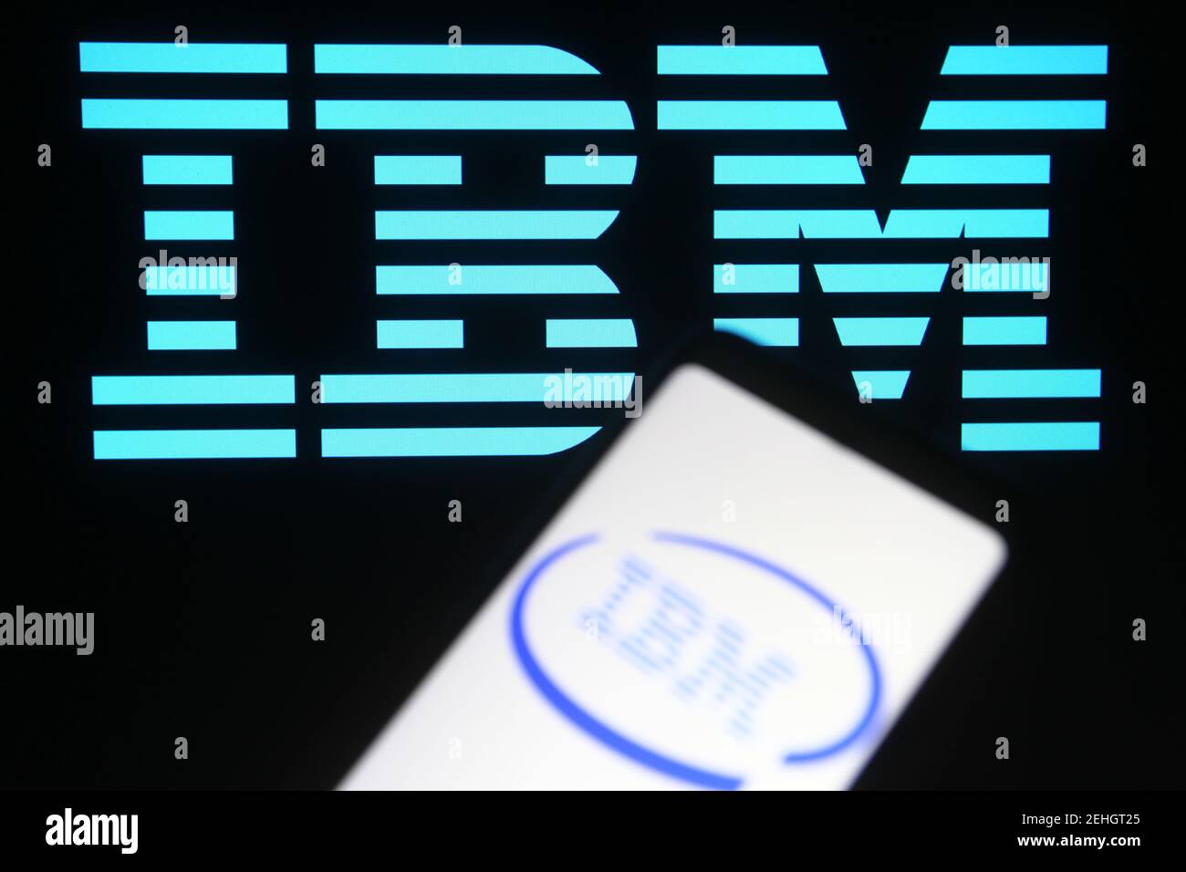 In this photo illustration an IBM logo is seen on a smartphone and a pc ...