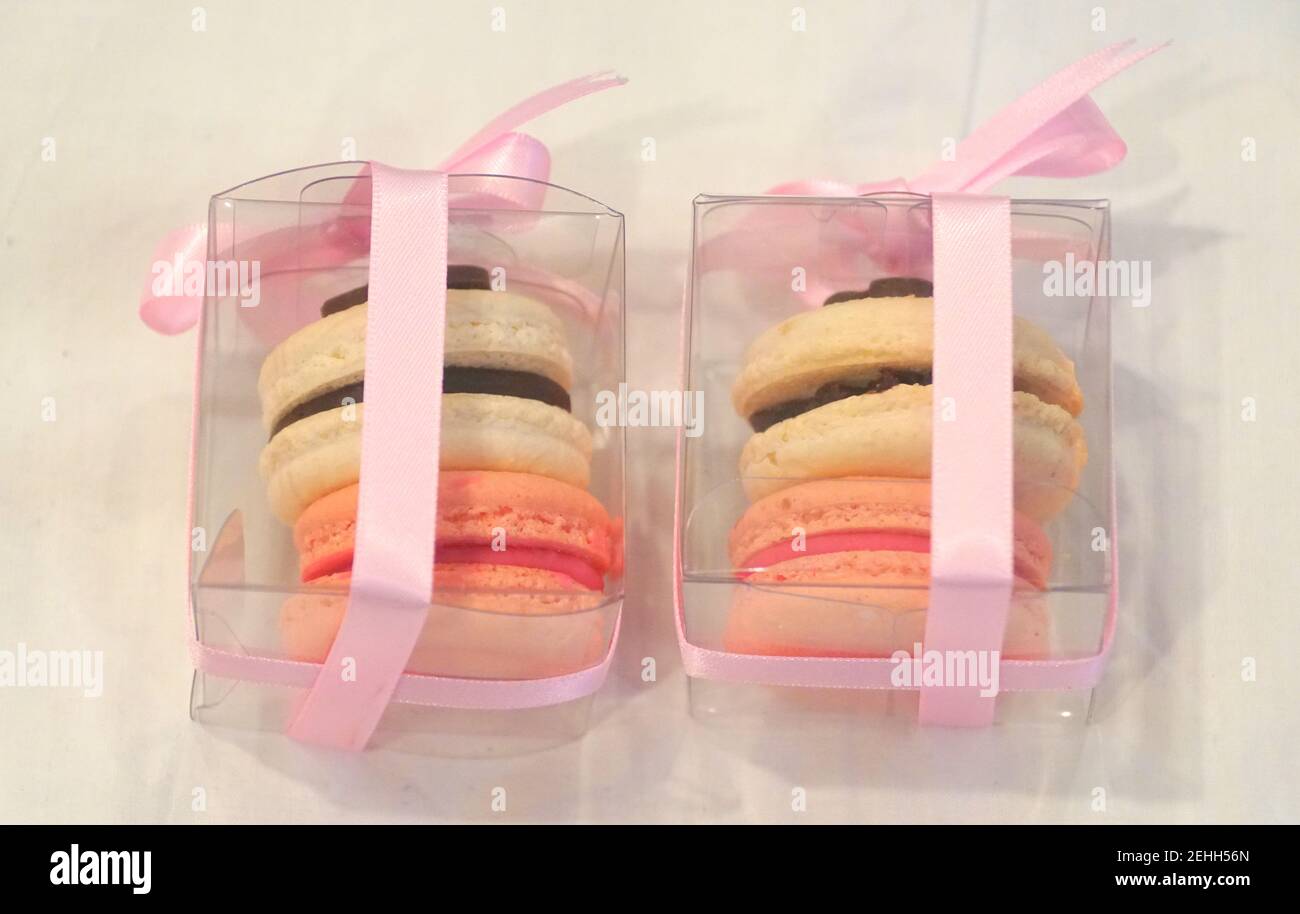 The macarons biscuits inside a see-through box as door wedding gift ...