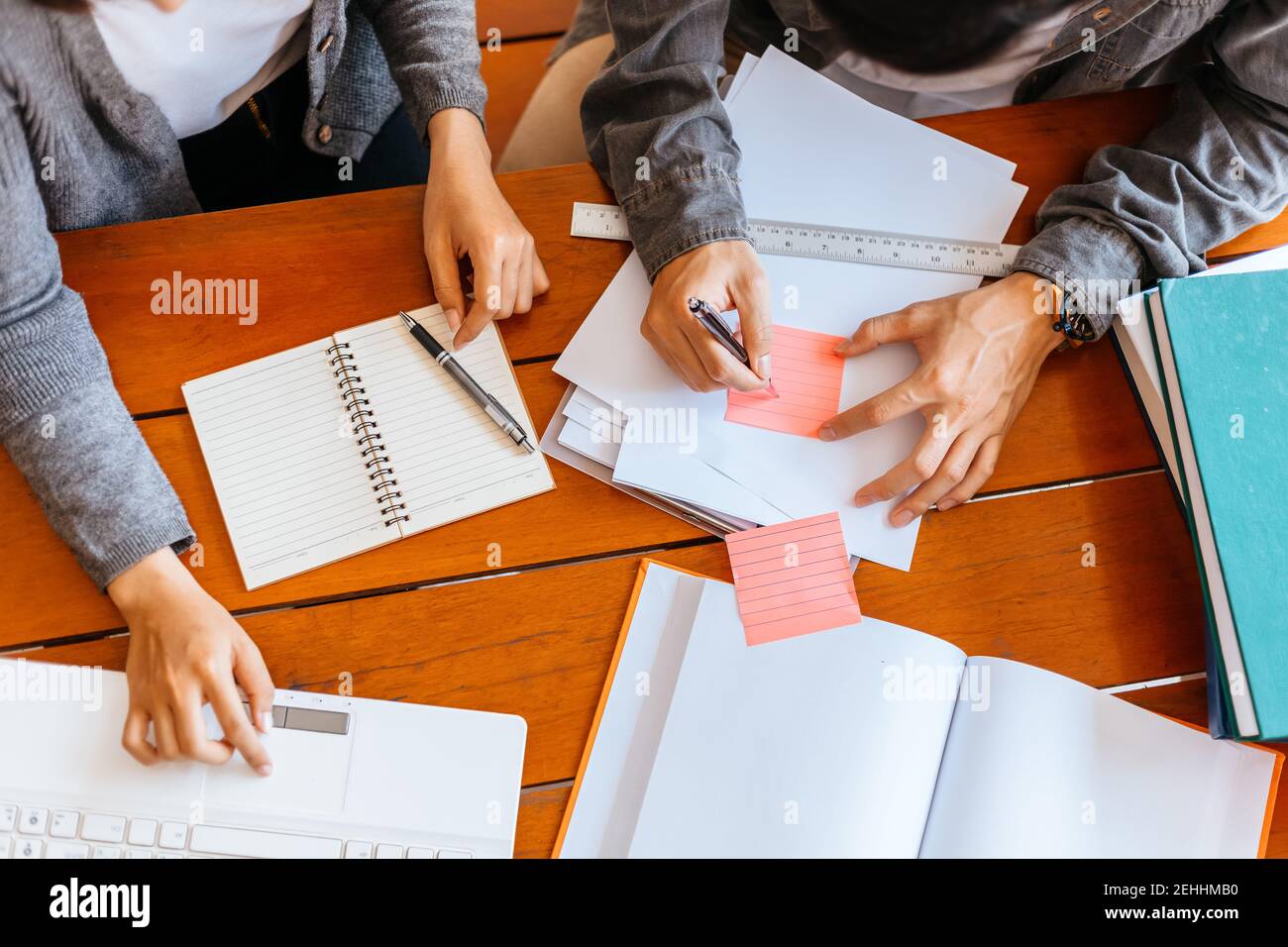 High school or college students group catching up workbook and learning ...
