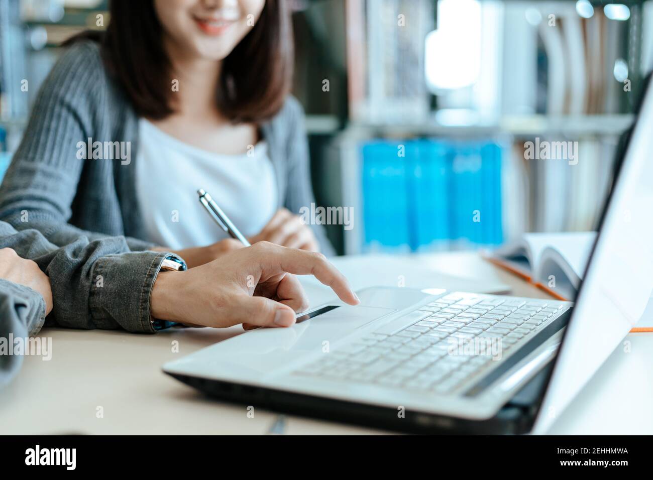 Students studying in the library with laptop at the university ...