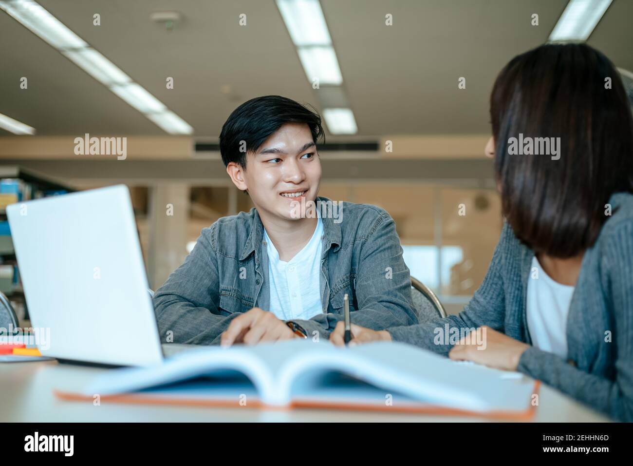Students studying in the library with laptop at the university ...