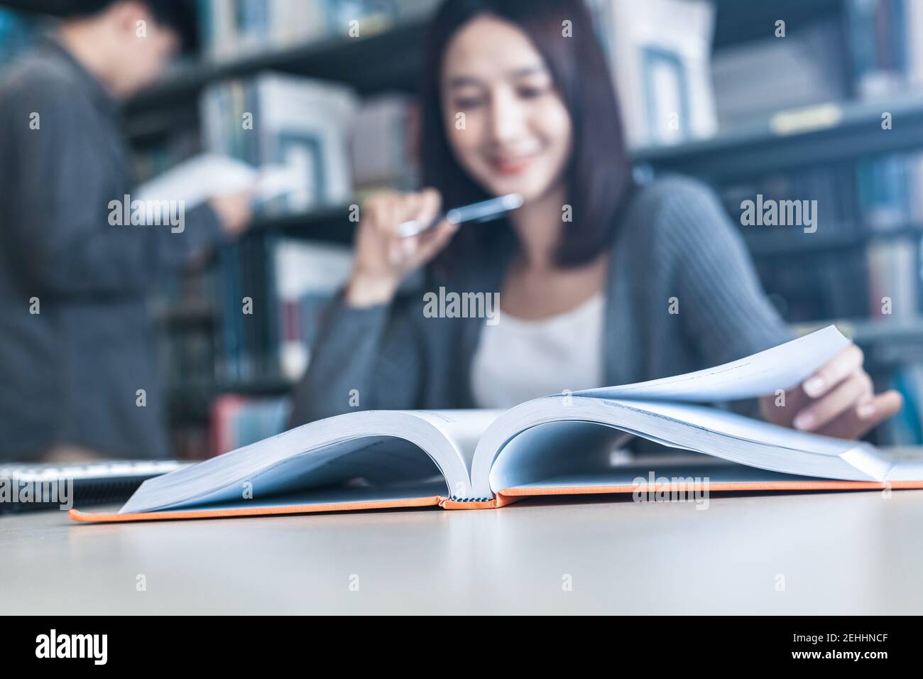 Student open a book and read for exam in the library. Education concept ...