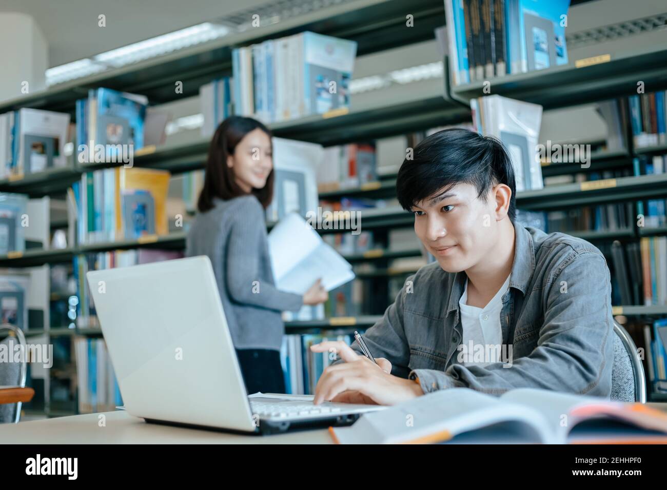 Students studying in the library with laptop at the university ...