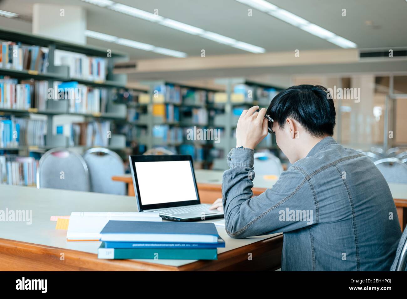 Students studying in the library with laptop at the university ...