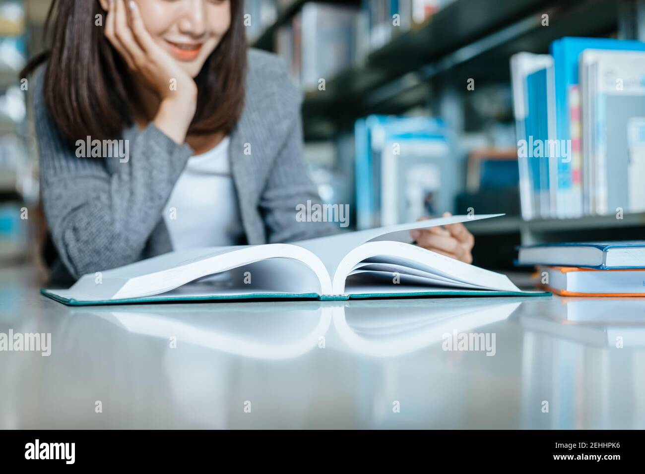 Student college opening and reading a book at library Stock Photo - Alamy