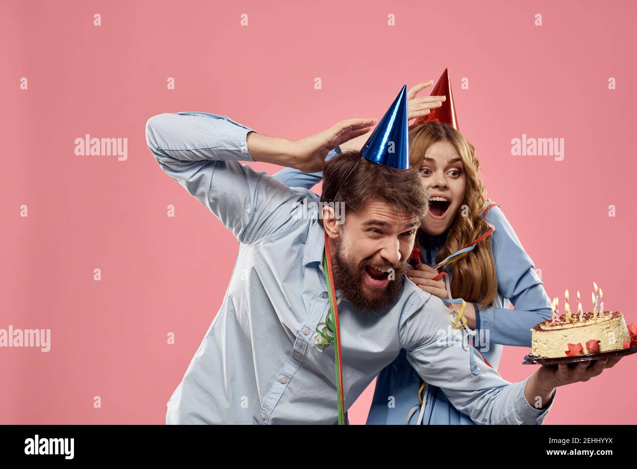 Party man and woman corporate pink background fun cake cap Stock Photo ...
