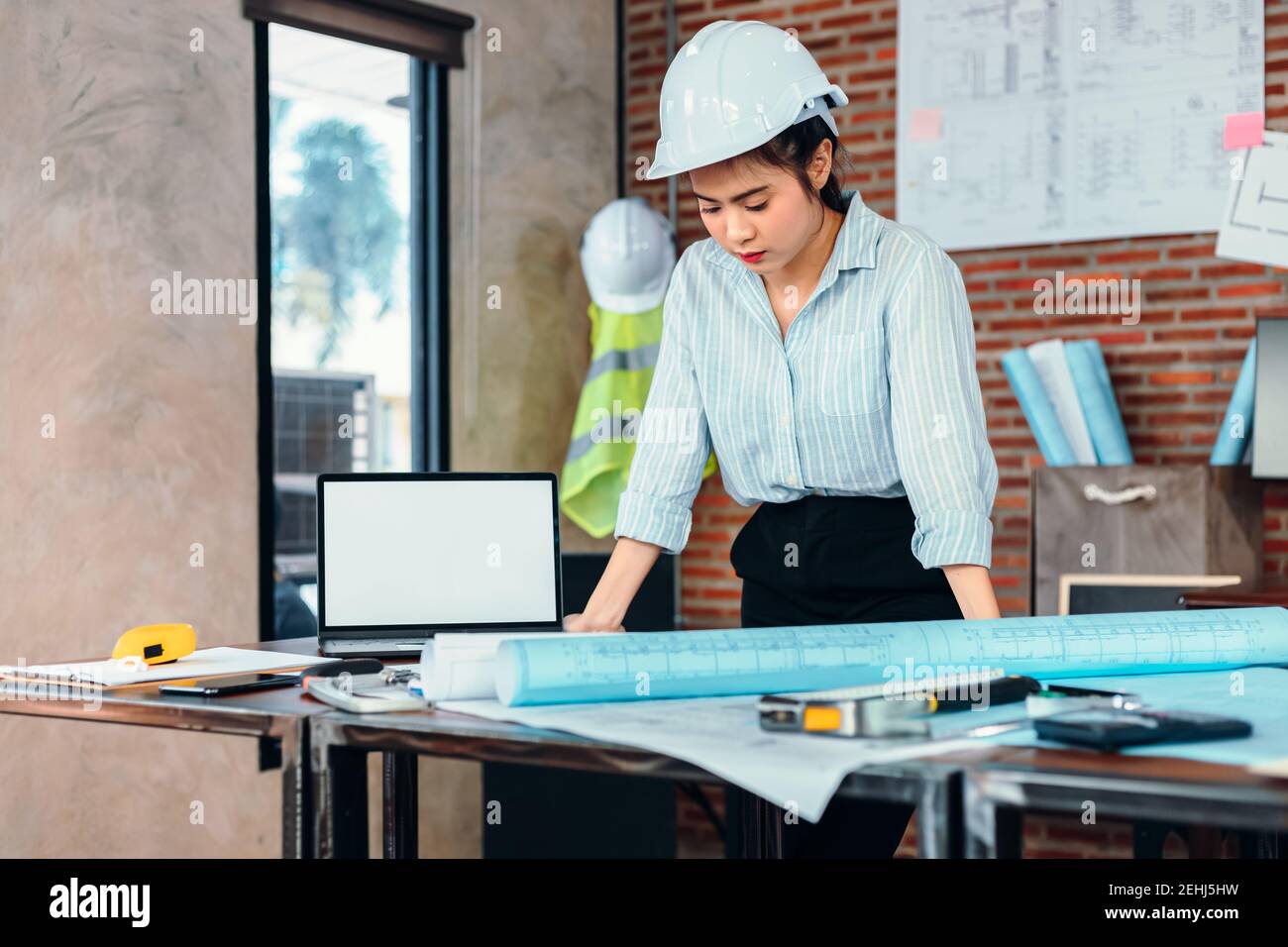 Engineer woman read drawing blue print on table workplace at room site ...