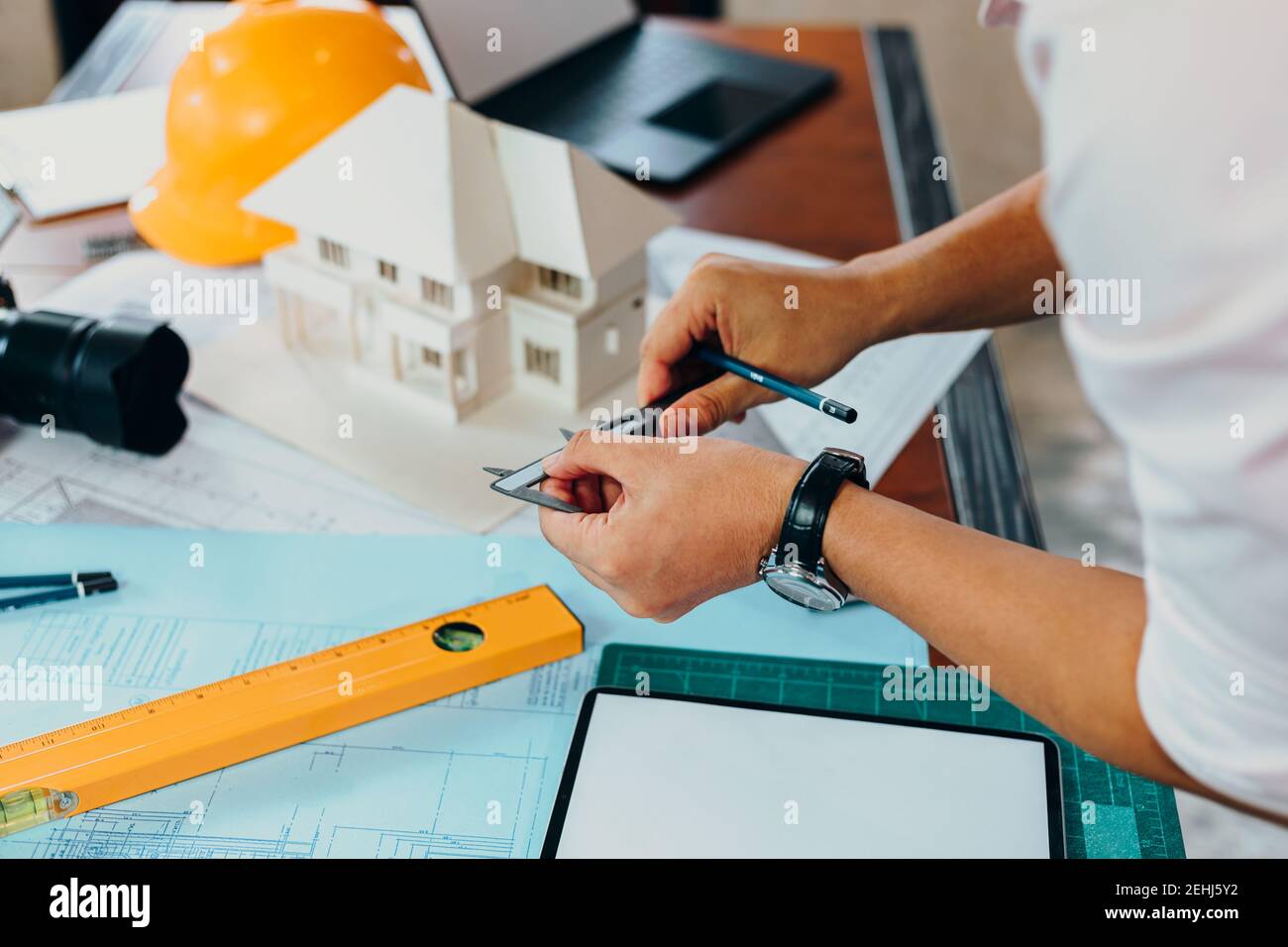 Engineering hands hold vernier caliper and pen for working and checking ...