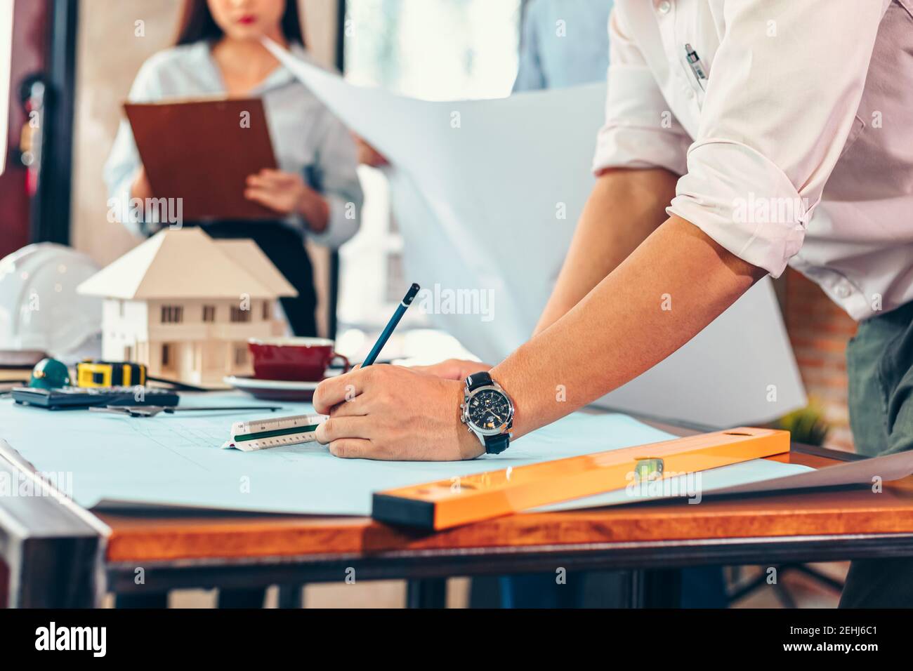 engineers holding a pen pointing to a building and drawing outlay ...
