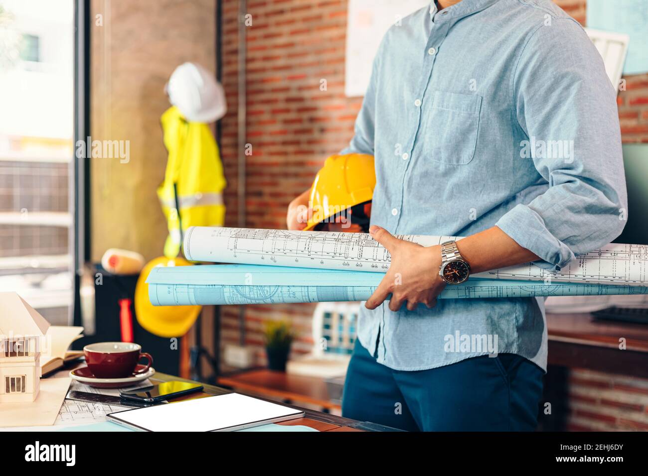 engineer hold engineer drawing design blueprints and safety helmet in ...