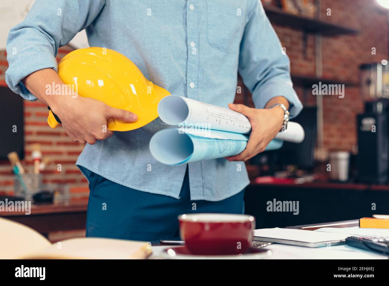 engineer hold engineer drawing design blueprints and safety helmet in ...