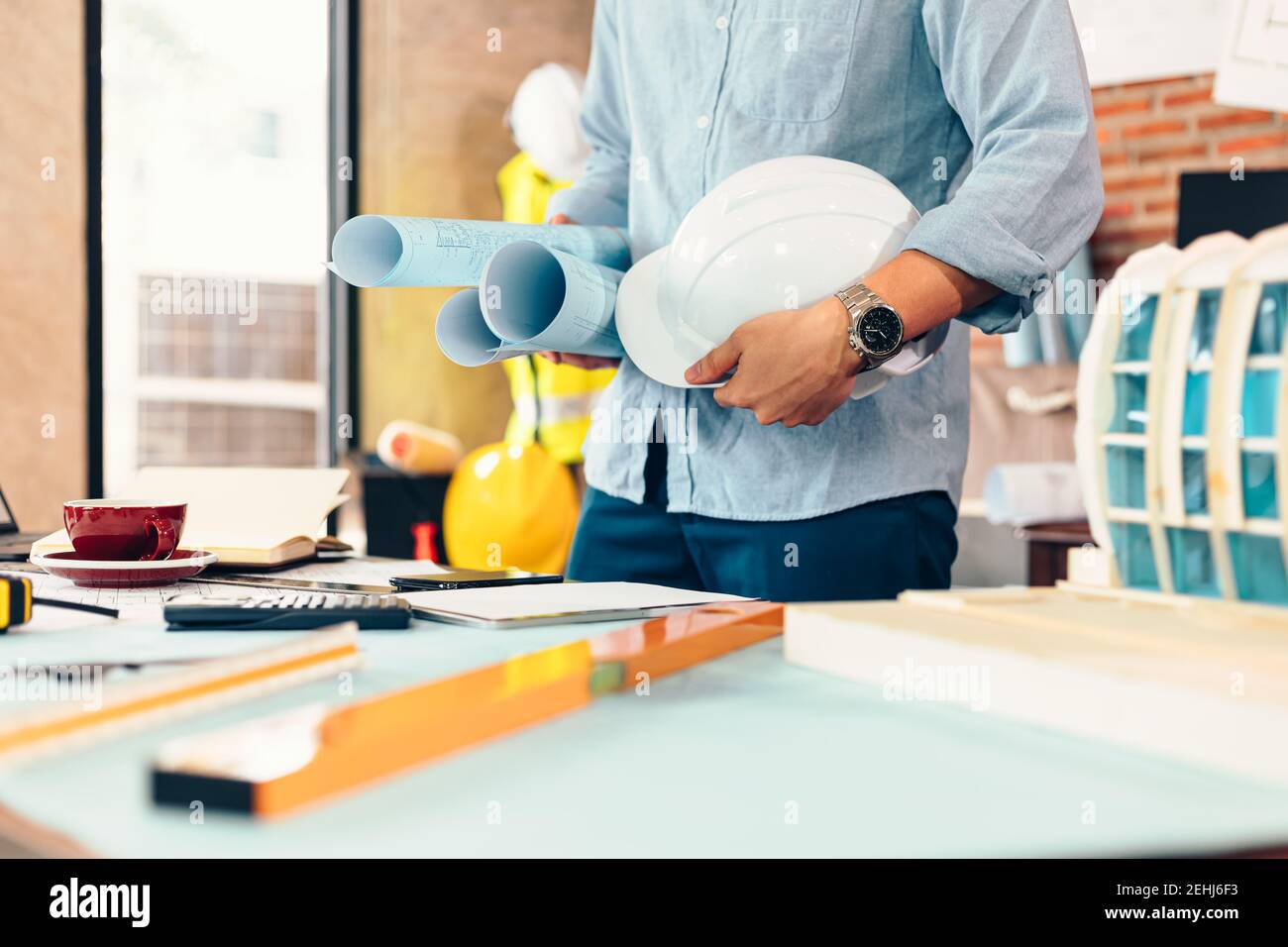 engineer hold engineer drawing design blueprints and safety helmet in ...