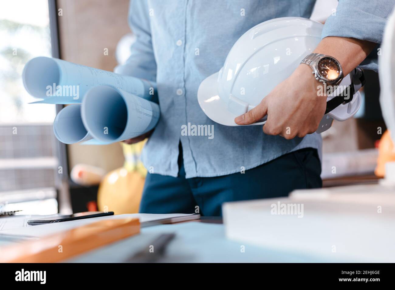 engineer hold engineer drawing design blueprints and safety helmet in ...