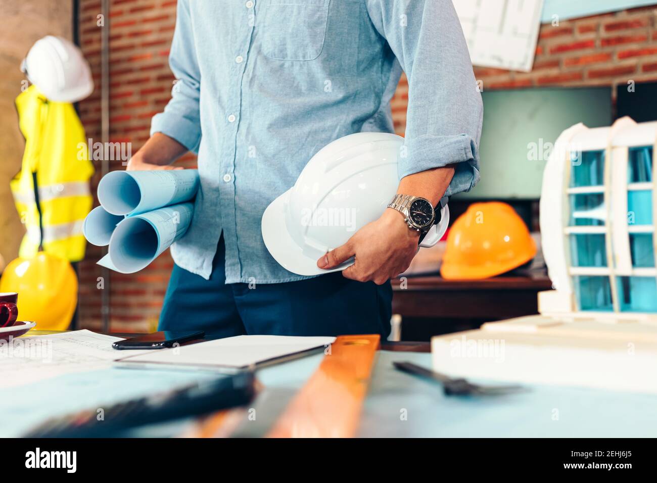 engineer hold engineer drawing design blueprints and safety helmet in ...