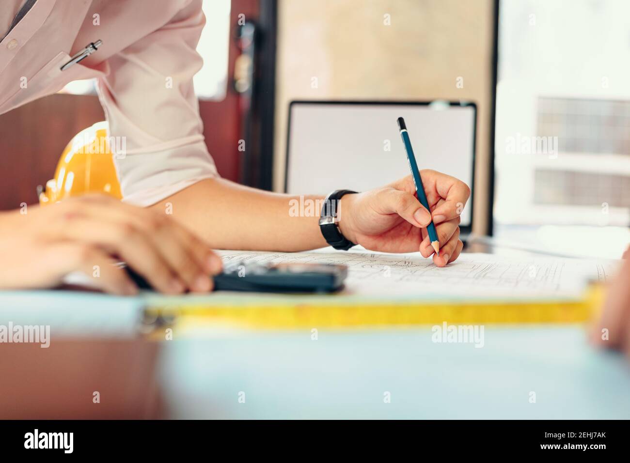 engineers holding a pen pointing to a building and drawing outlay ...