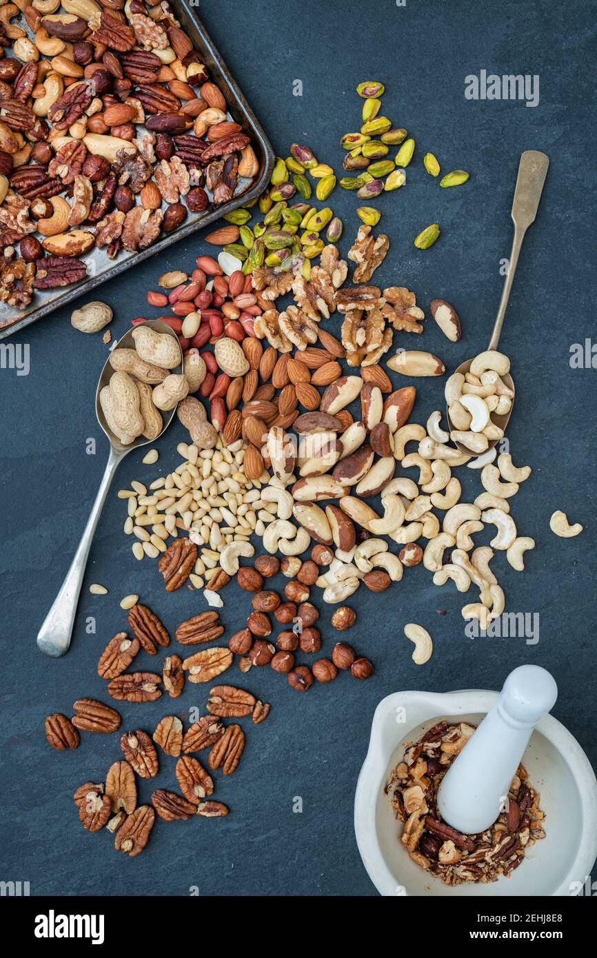 Various nuts with a tray of roasted nuts on a slate background Stock ...