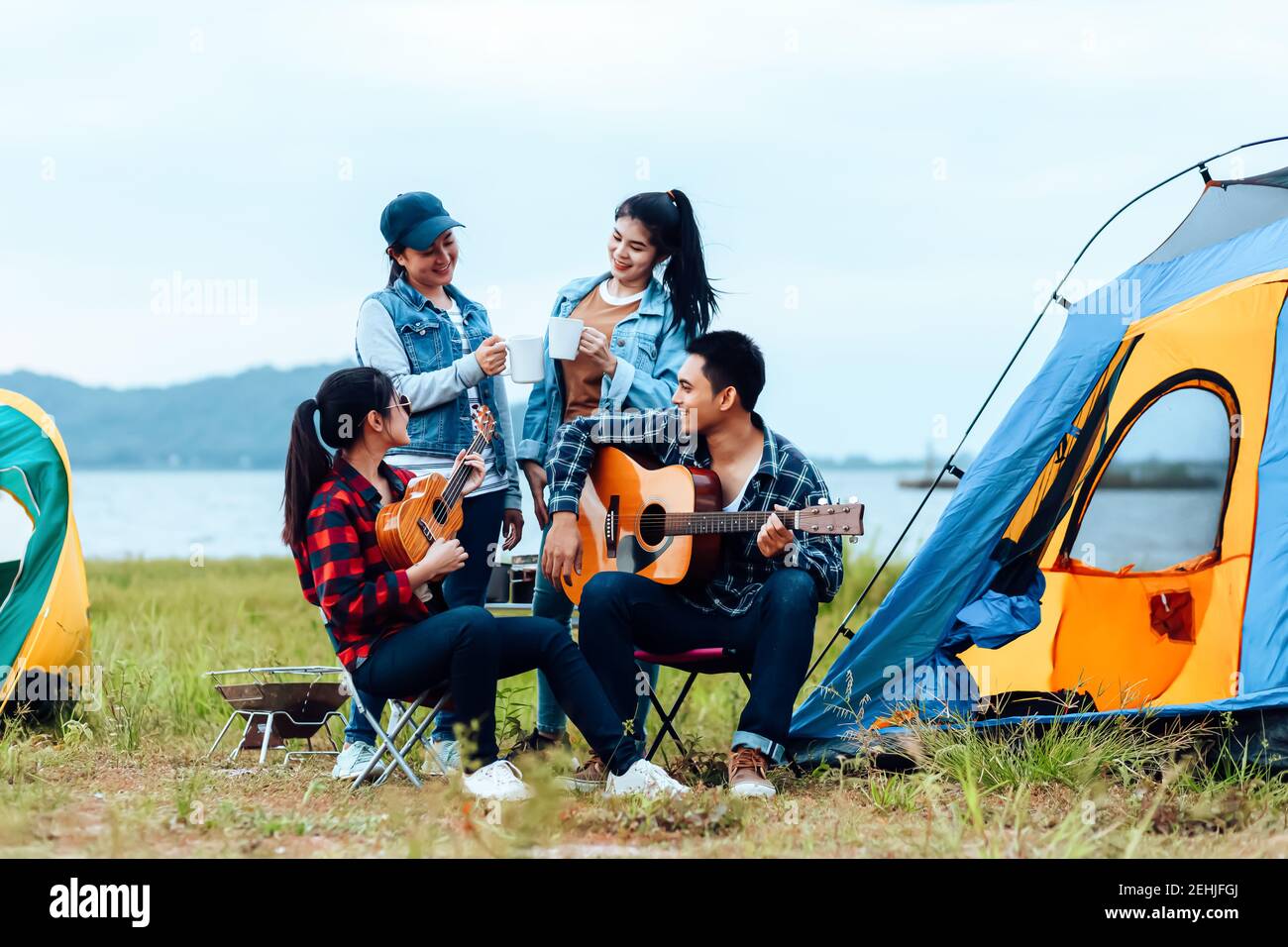 Group of friends camping and they are sitting playing guitar. Camp and ...