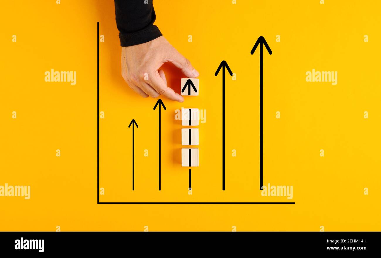 Male hand drawing a business line chart or graph with upward pointing ...