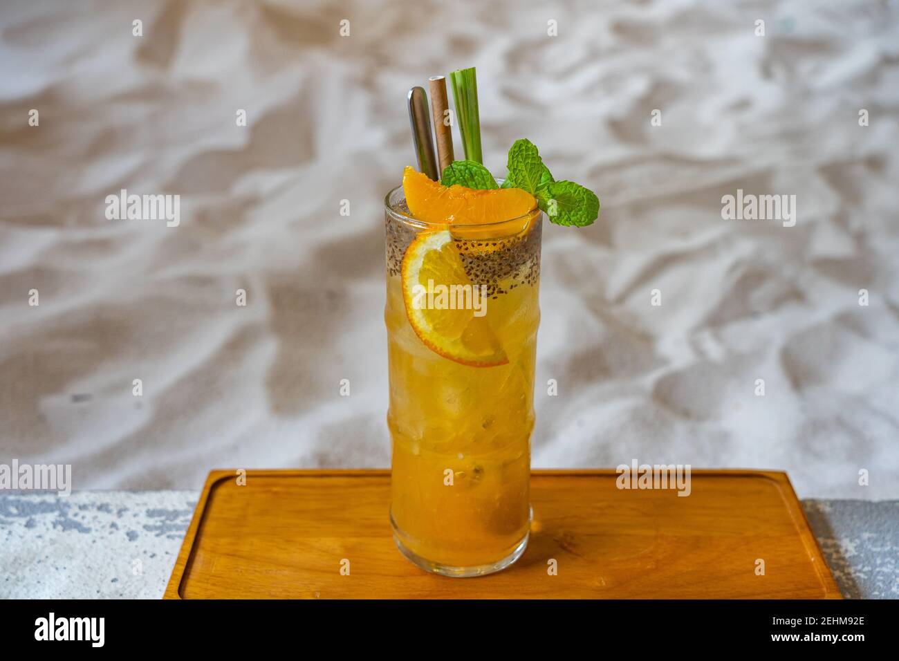 Close up photo of tropical fruit tea on white sand beach background ...