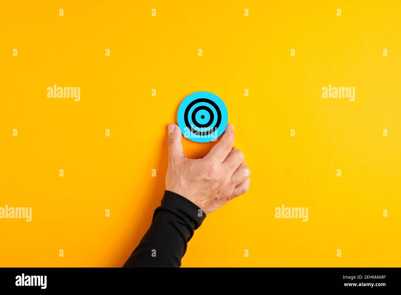 Male hand placing a blue badge with a target icon. Goal achievement in ...