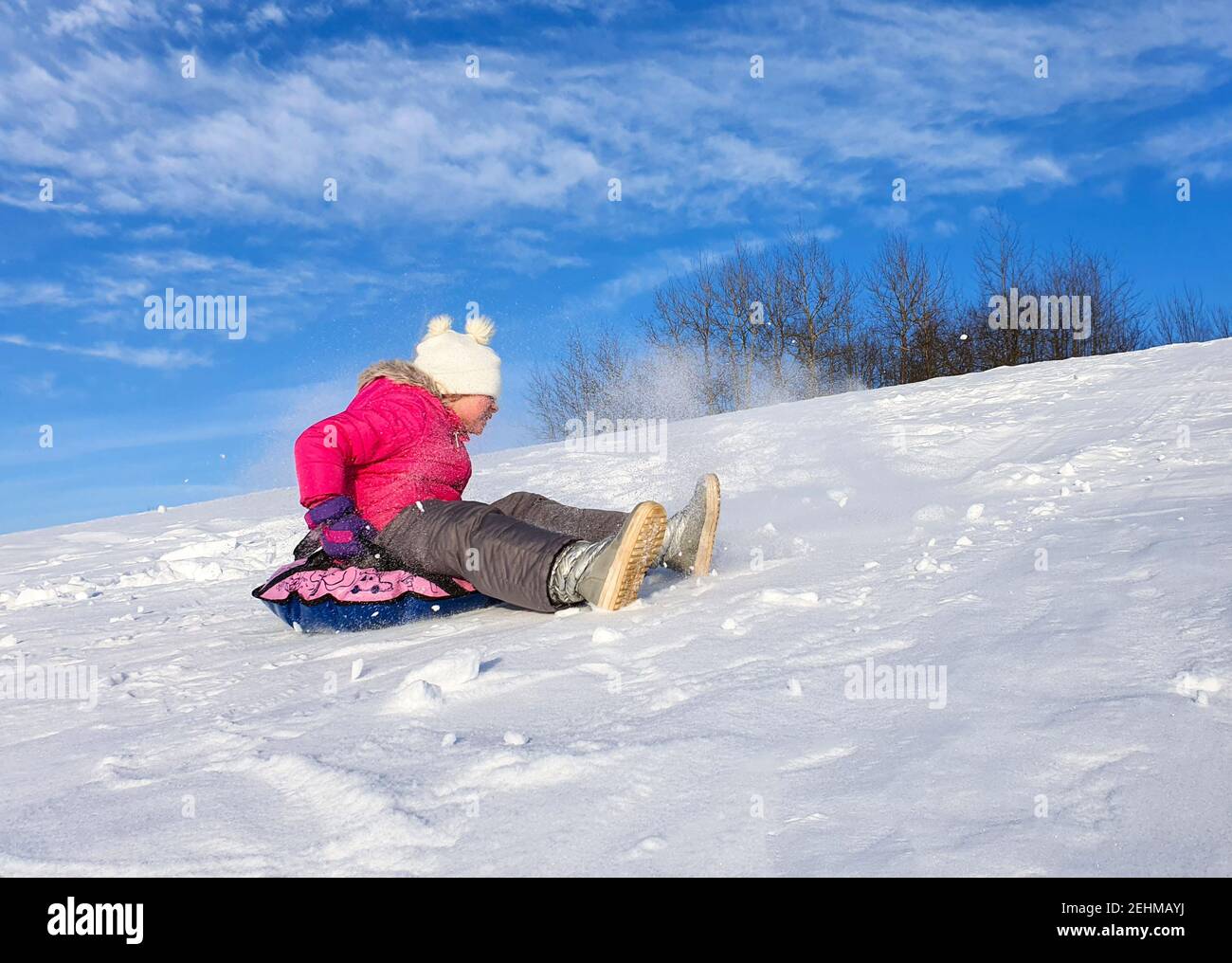 A child is tubing on a snow slide Stock Photo - Alamy