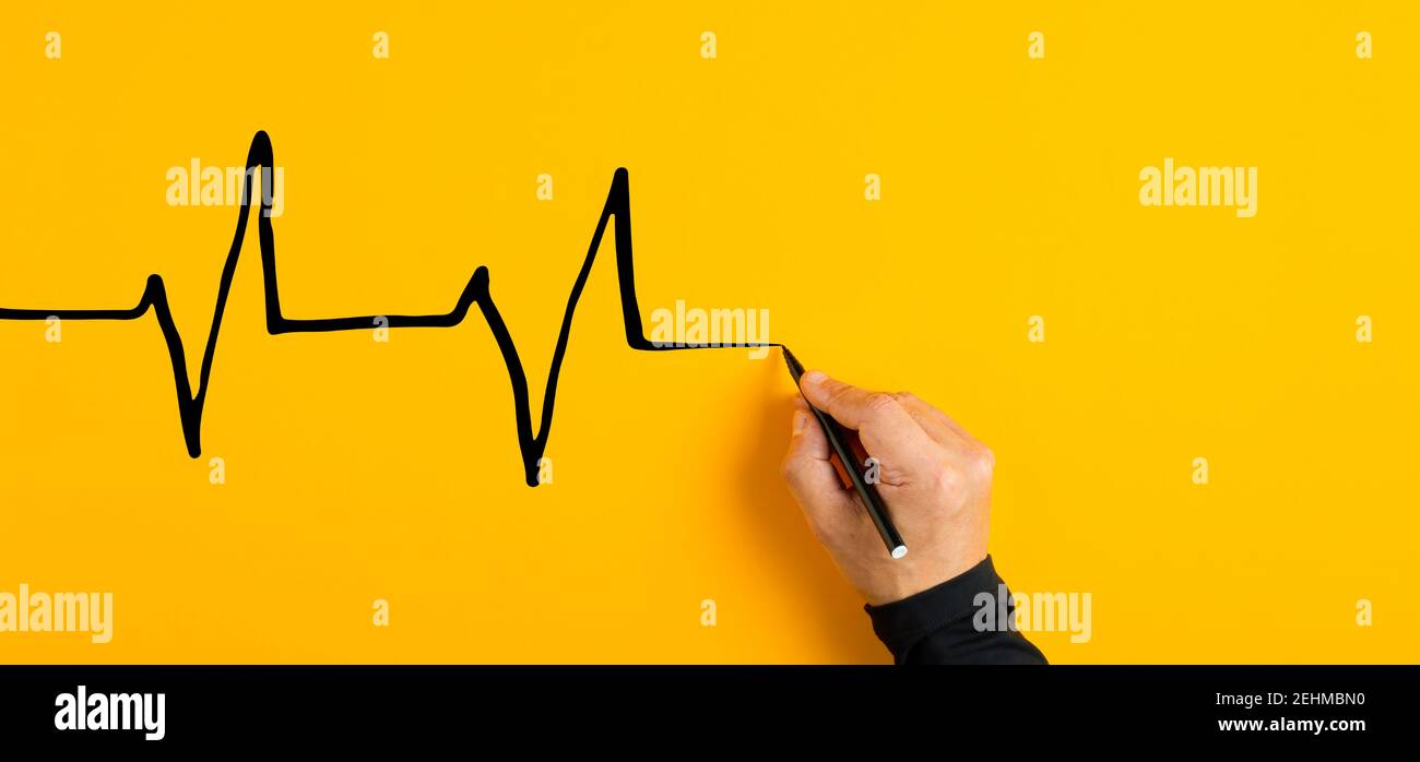 Male hand drawing a electrocardiogram heart beat chart on yellow ...