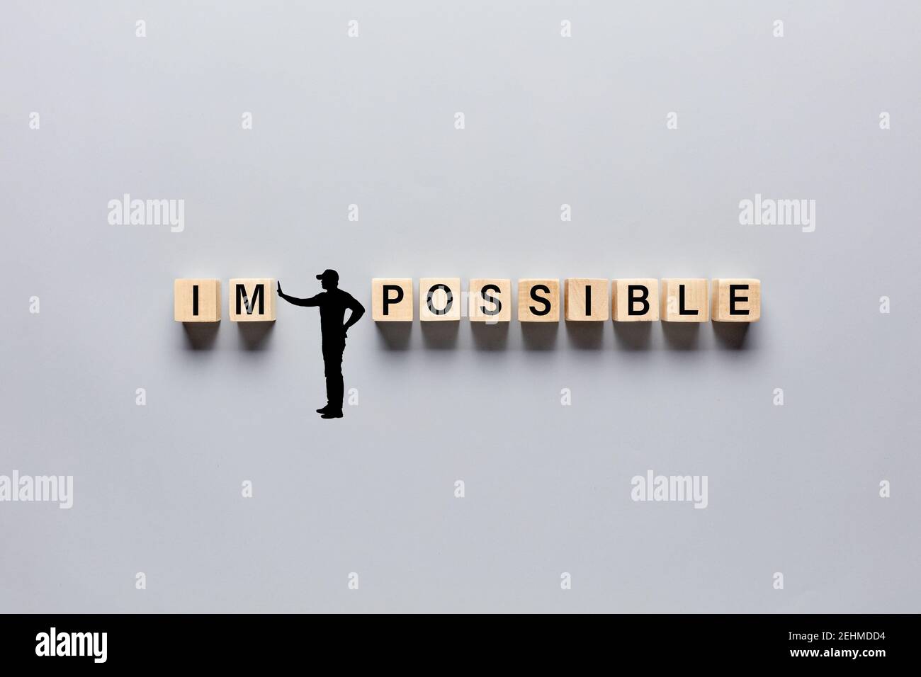 Silhouette of a hand drawn man transforming the word impossible into ...
