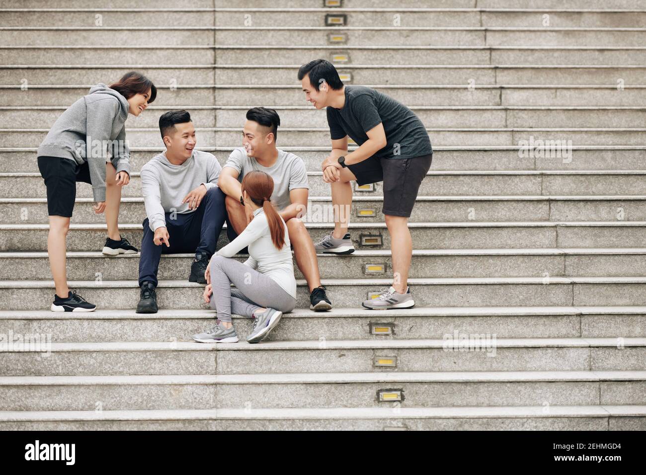 Fit people resting on steps Stock Photo - Alamy