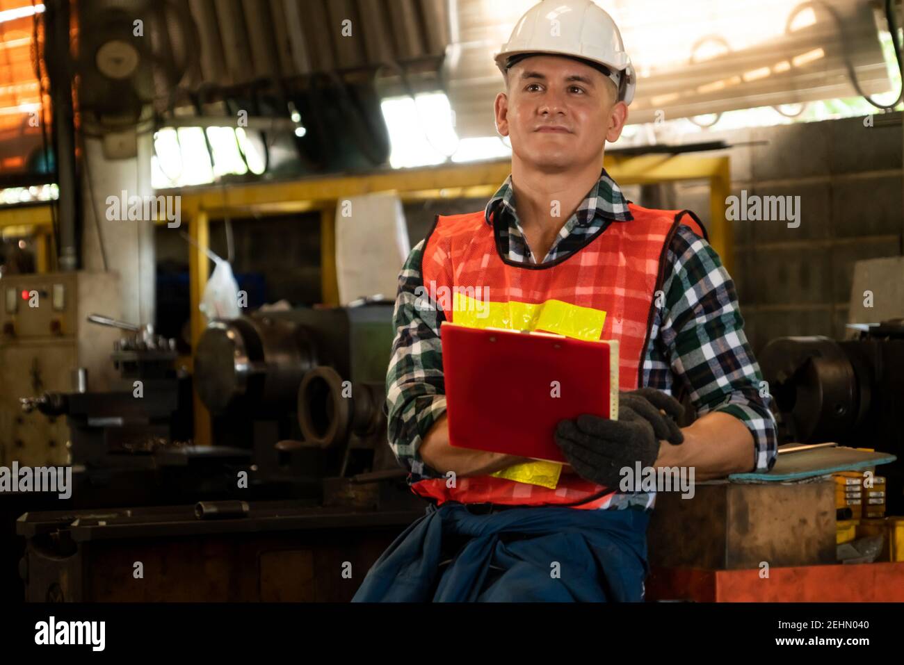 Manufacturing worker working with clipboard to do job procedure ...