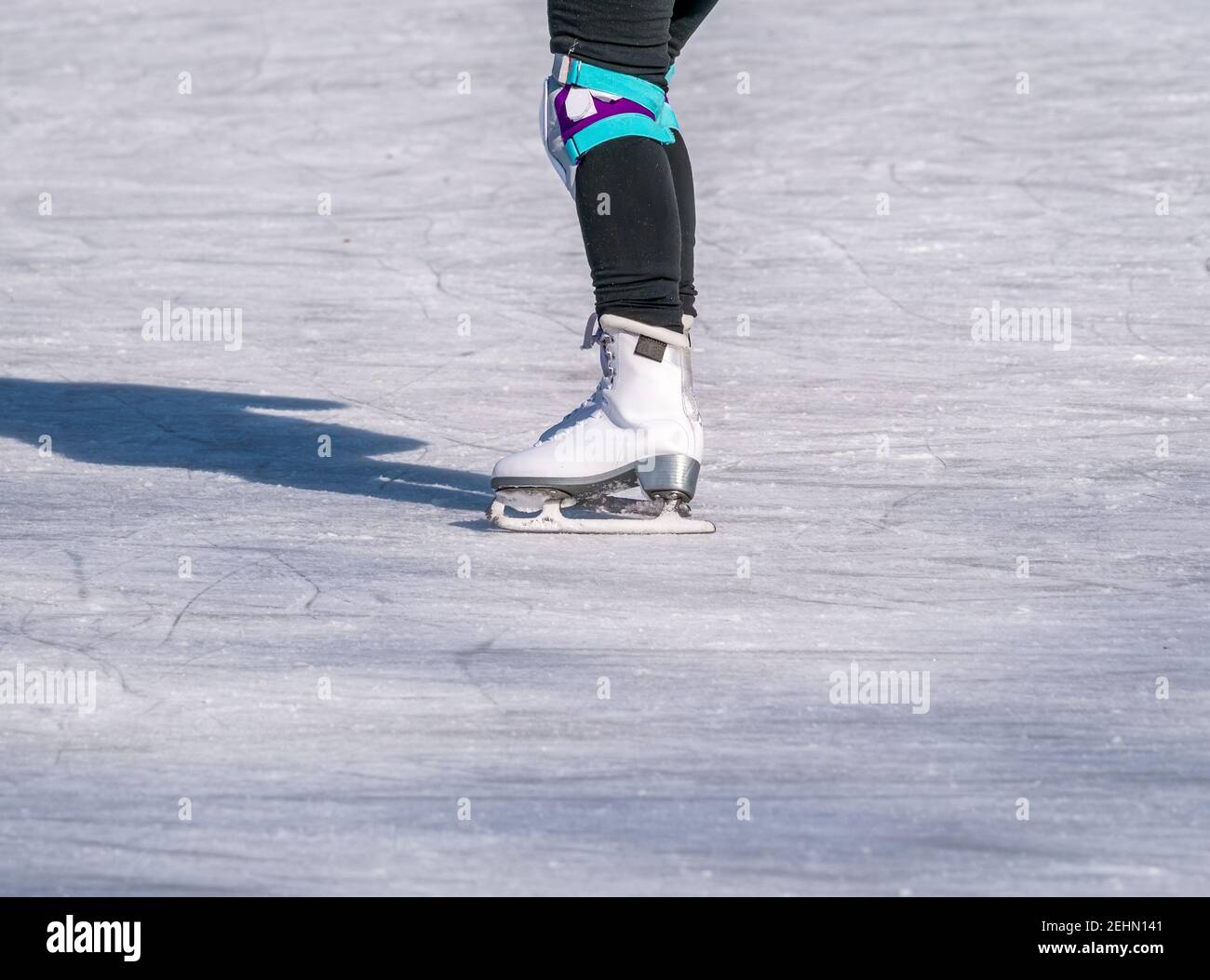 Legs of a woman with skates on ice. Ice skating recreational activity ...
