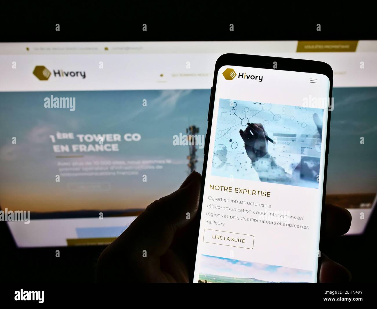 Person holding mobile phone with website and logo of French telecoms ...