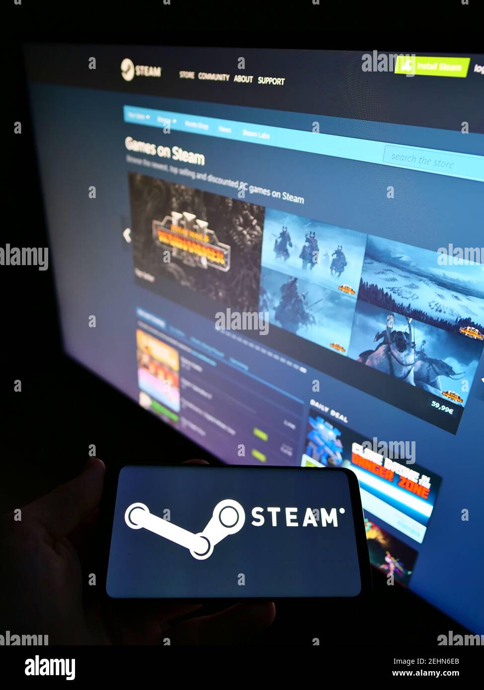 Person holding mobile phone with logo of distribution platform Steam ...