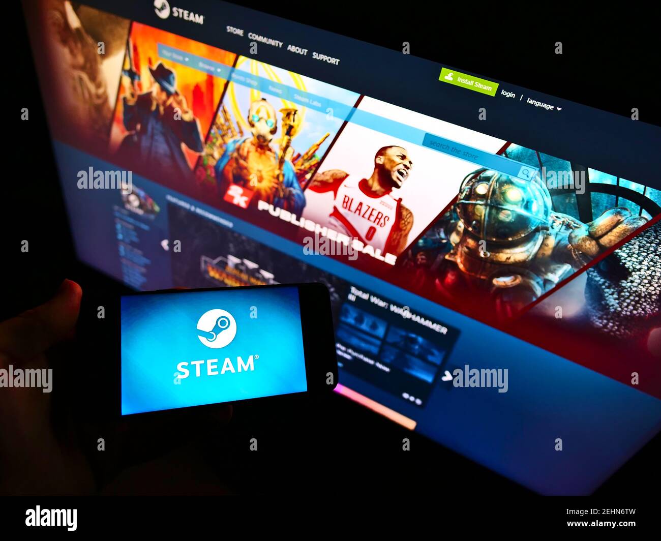 Person holding mobile phone with logo of US distribution platform Steam ...