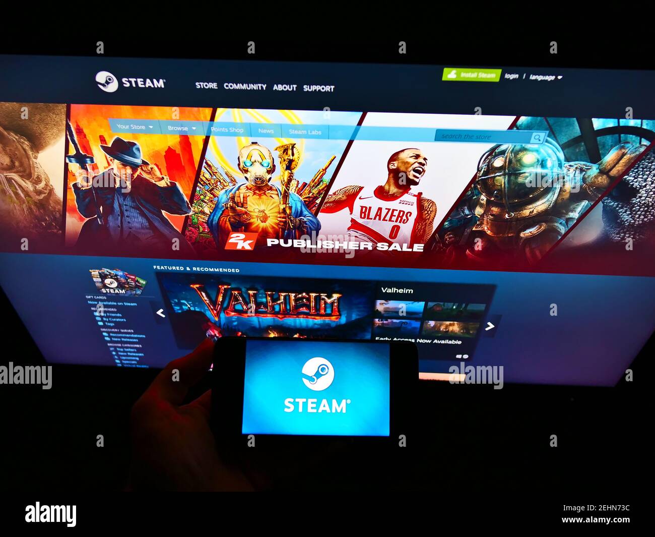 High angle view of person holding smartphone with logo of distribution ...