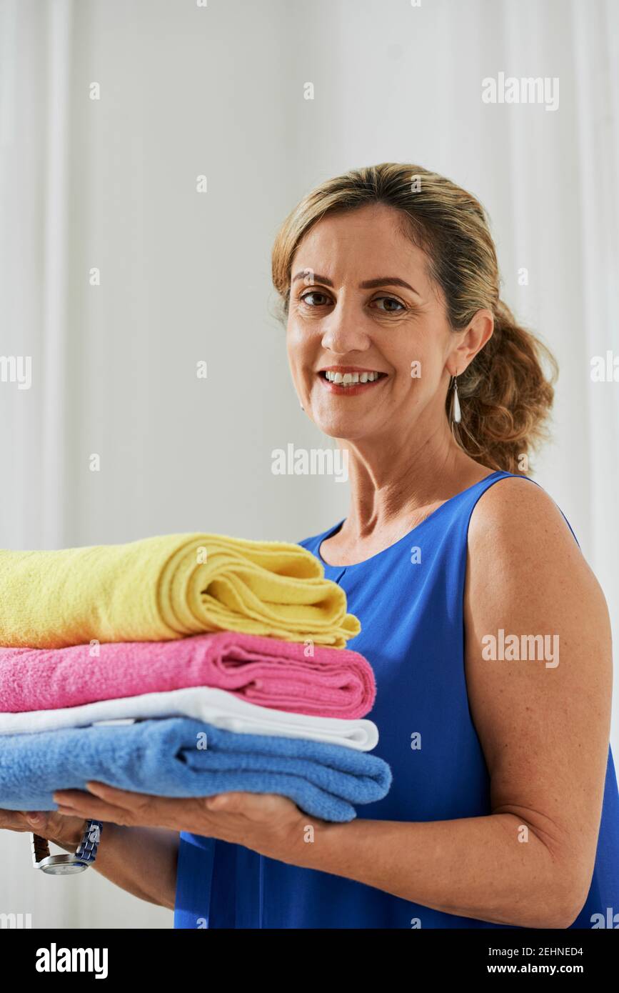 Woman carrying colorful towels Stock Photo - Alamy