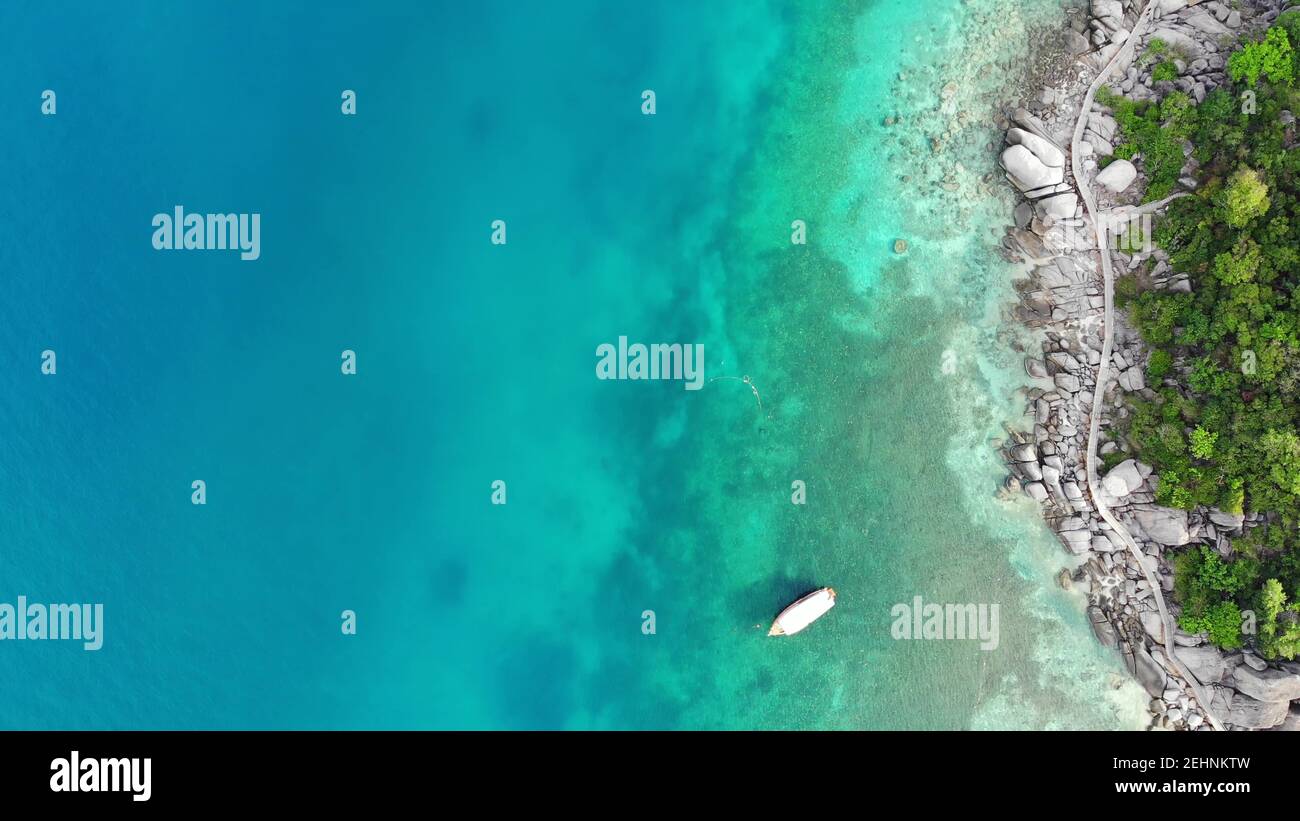 Calm colorful azure turquoise sea near tiny tropical volcanic island ...