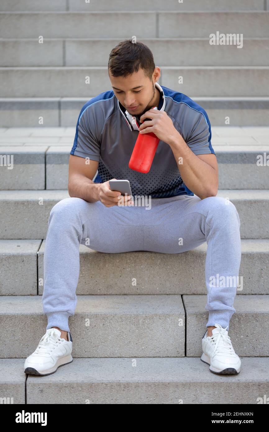 Young man looking at phone portrait format outdoor Stock Photo - Alamy