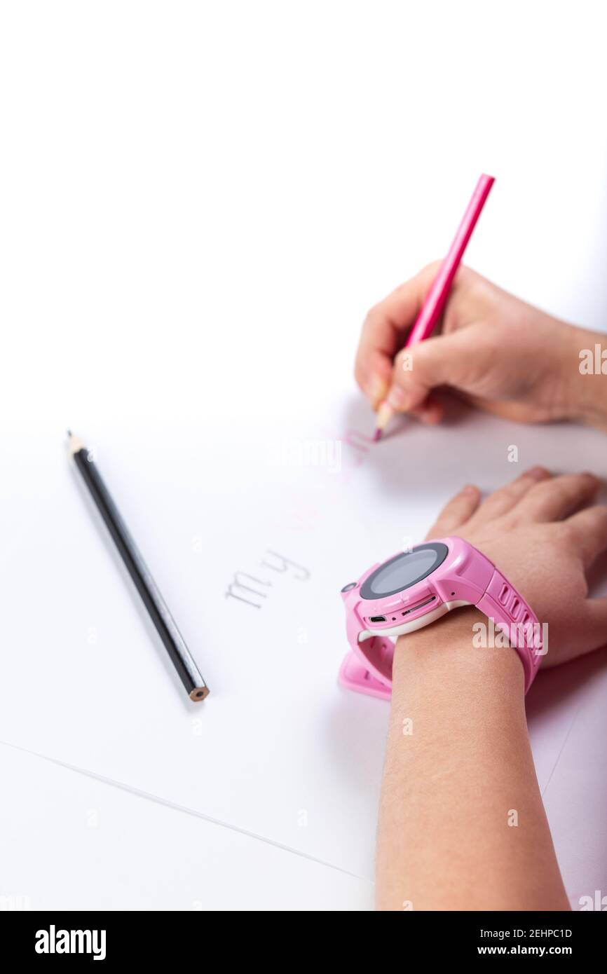 Child painting with pencils and pink smart watch on hand Stock Photo ...