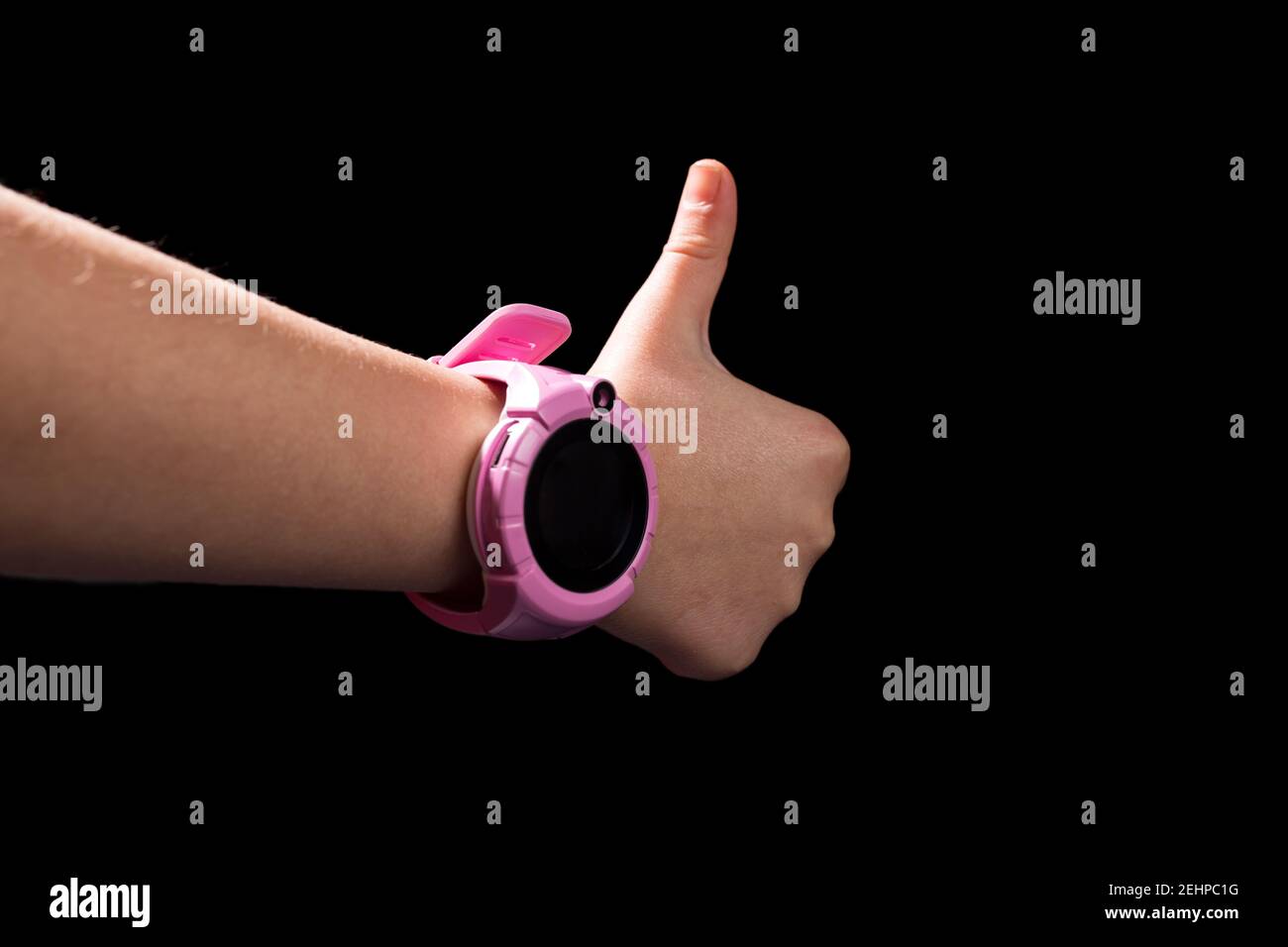 Child hand with pink smart watch, showing thump isolated on black Stock ...