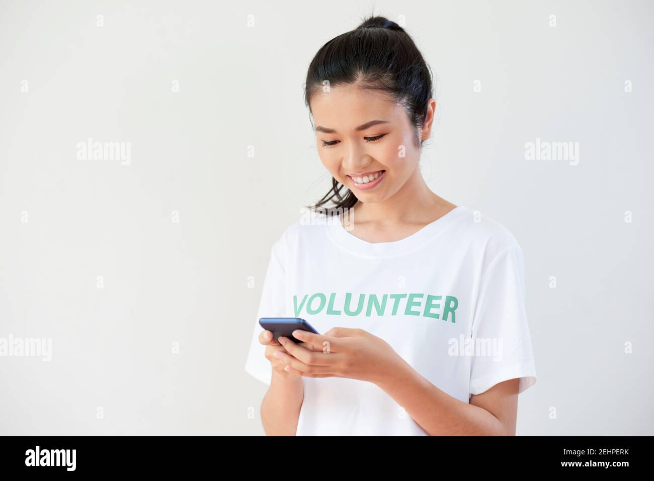 Volunteer texting friends Stock Photo - Alamy