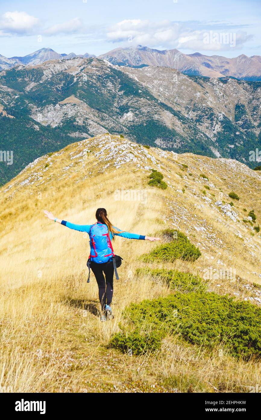 Vertical shot of female hiking on a mountain field Stock Photo - Alamy