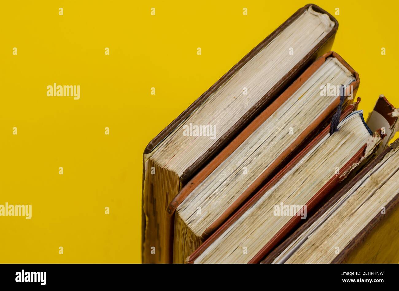 Four old diaries standing on endpaper on yellow background. The diaries ...