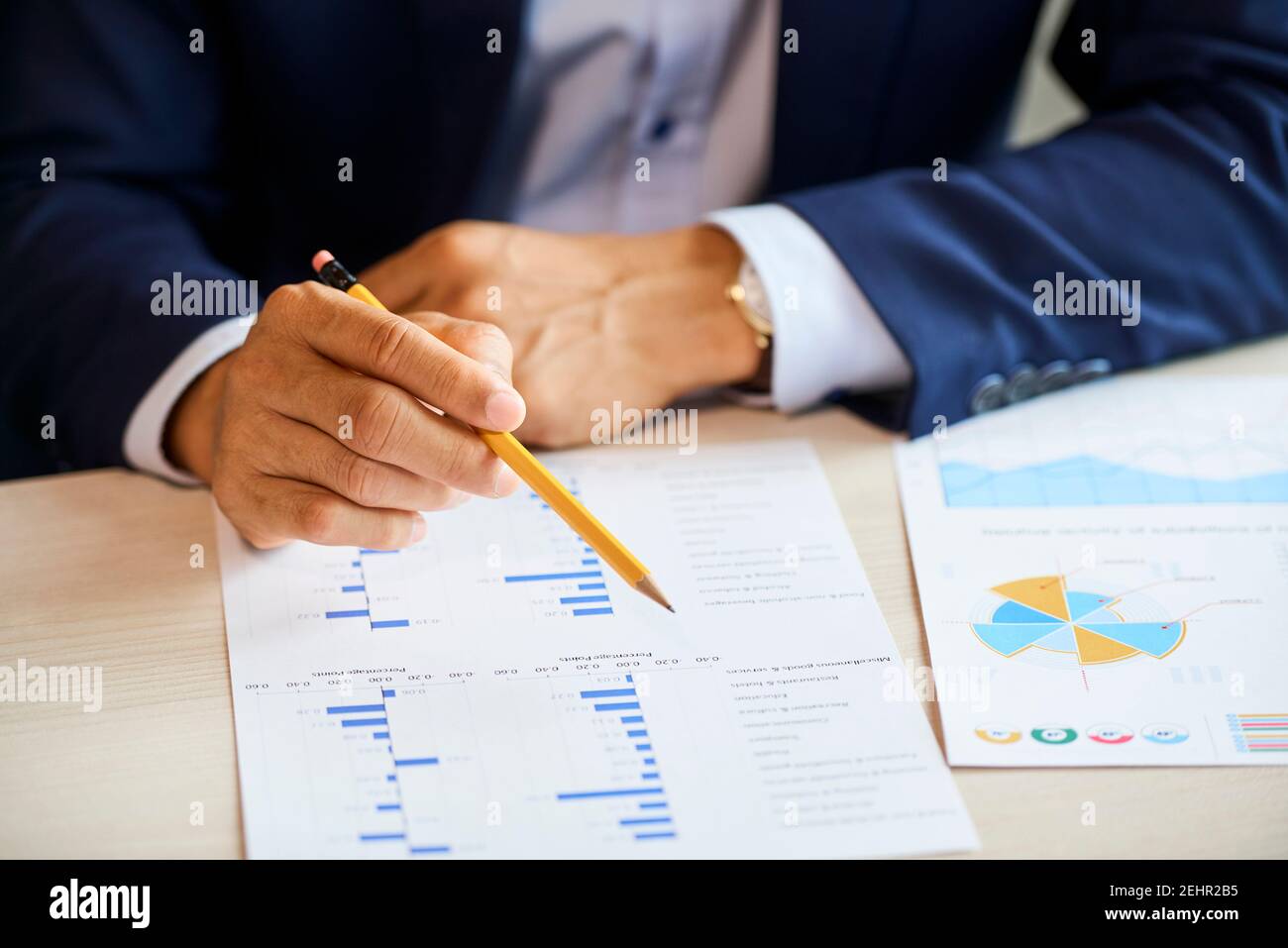 Businessman with pencil checking chart Stock Photo - Alamy