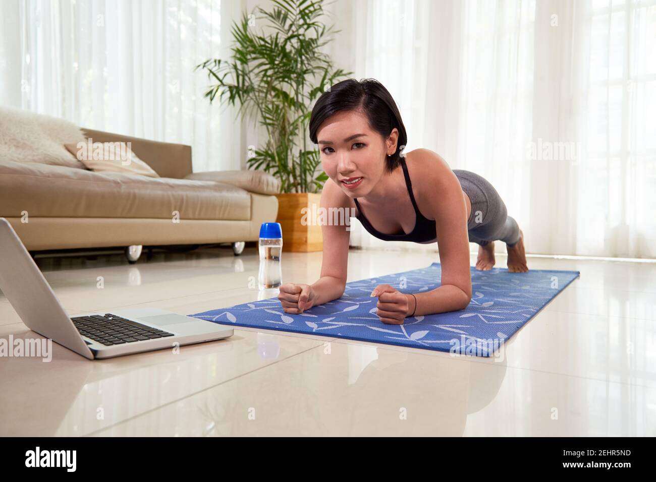 Woman standing in plank position Stock Photo - Alamy