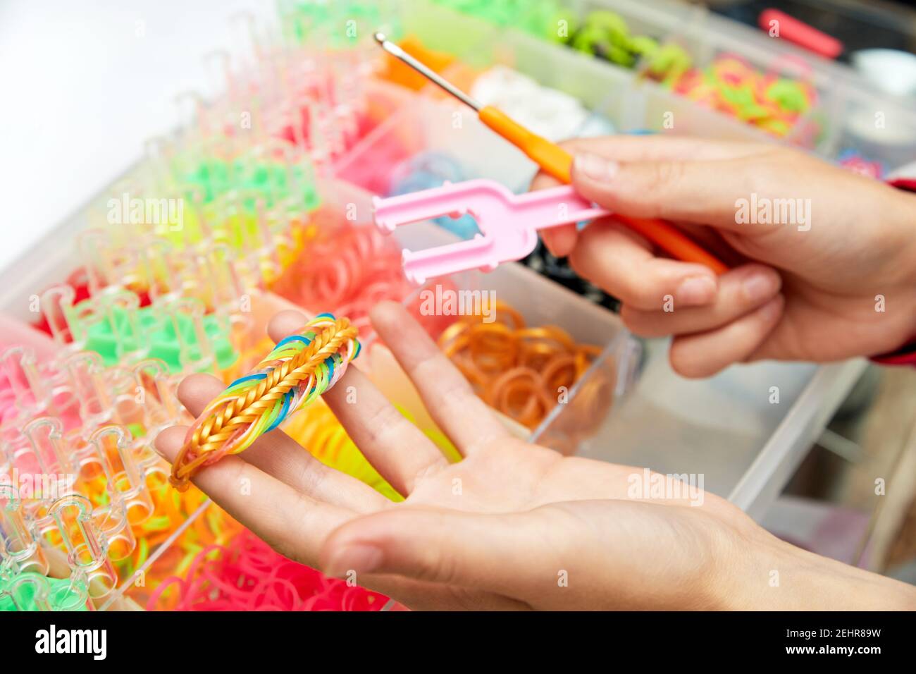 Rubber Band Weaving. Knitting rubber bands with loom knit. Hands of ...