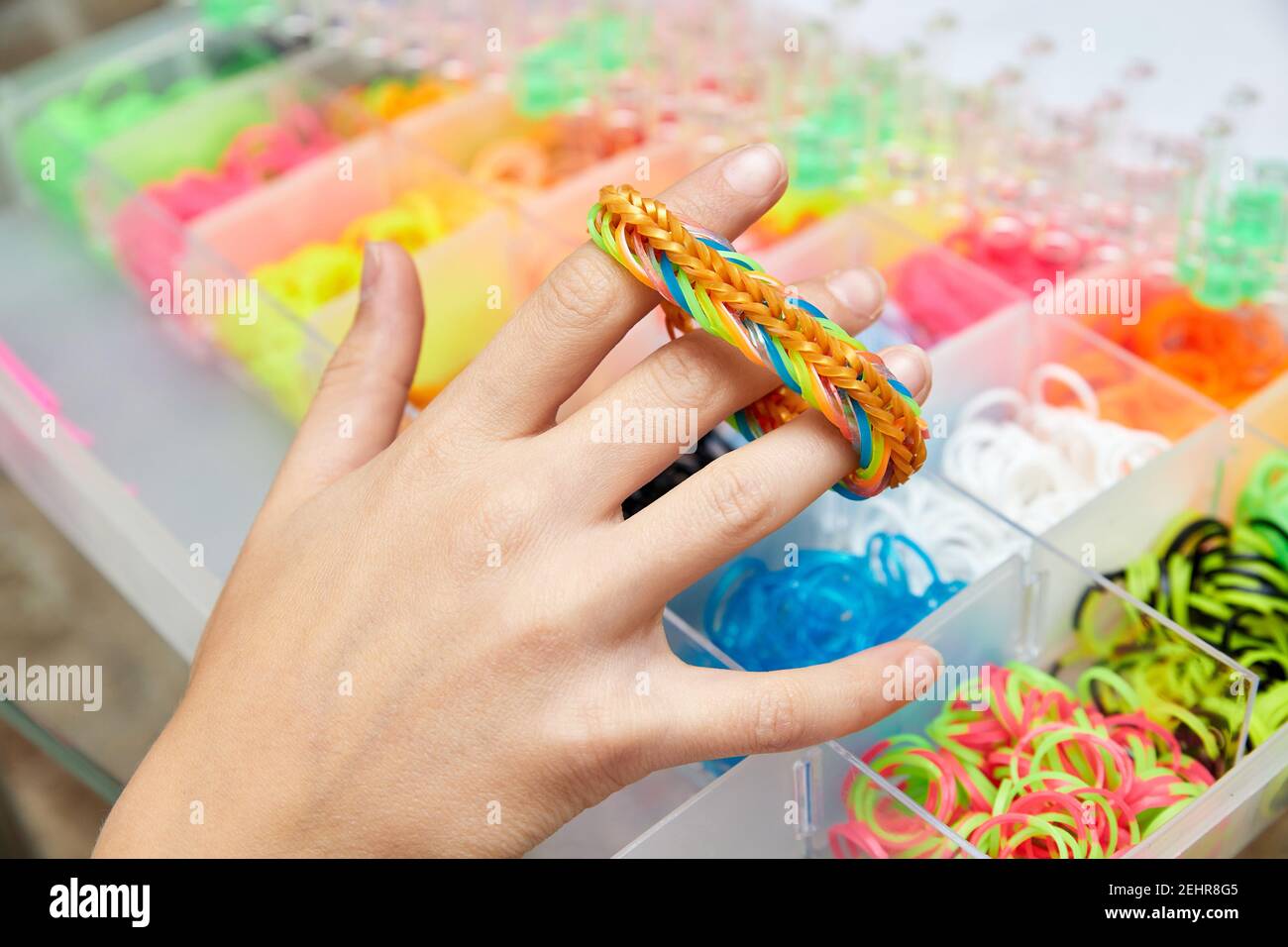 Rubber Band Weaving. Knitting rubber bands with loom knit. Hands of ...