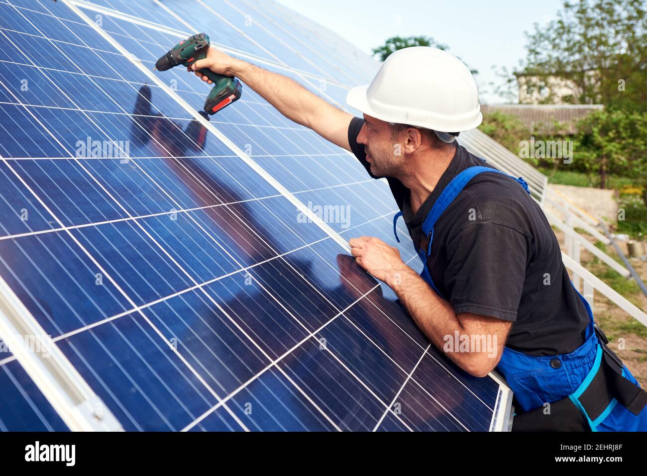 Technician installing solar panel to metal platform using electrical ...